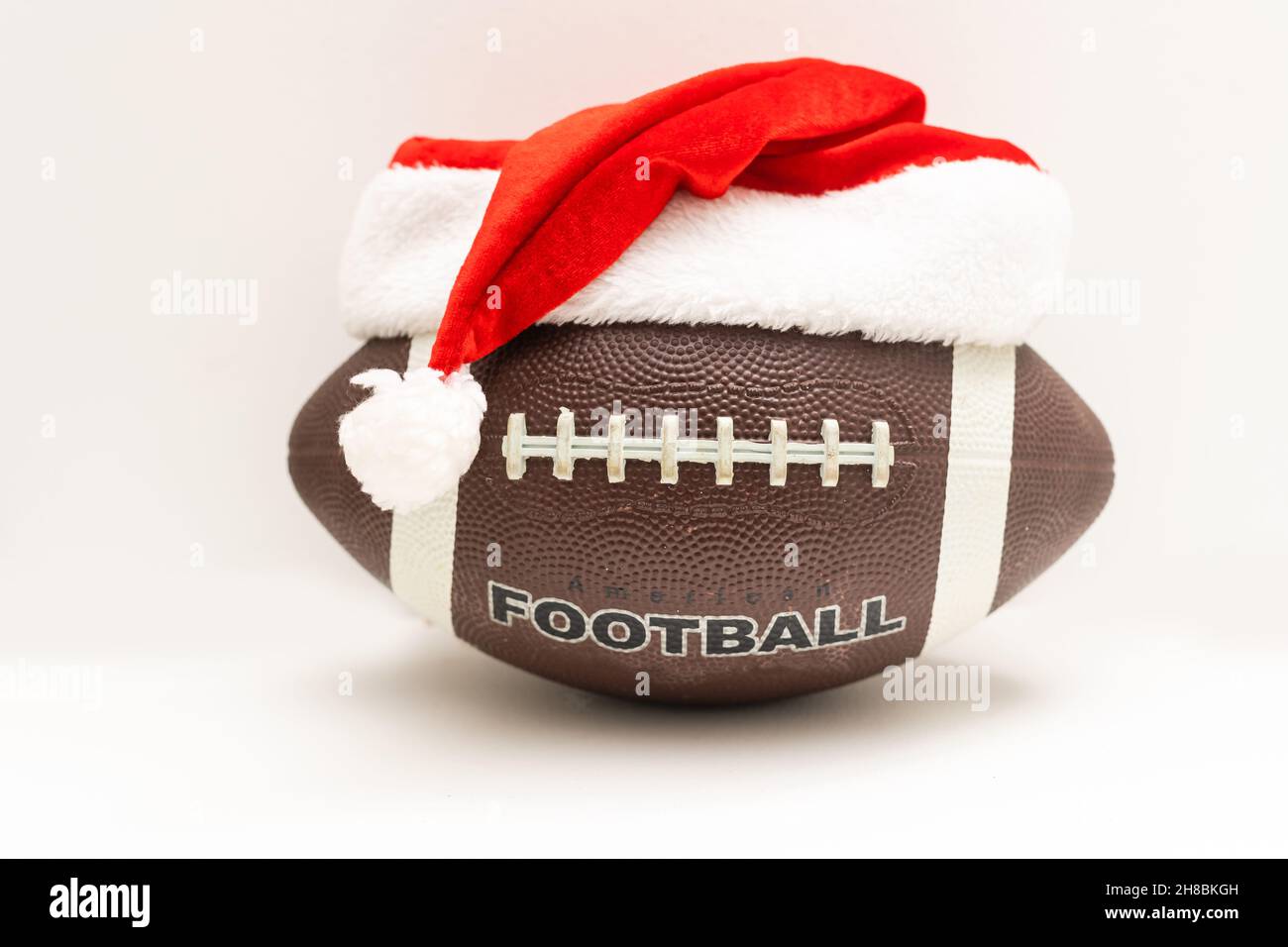 A souvenir ball for rugby or american football in a red santa claus hat ...