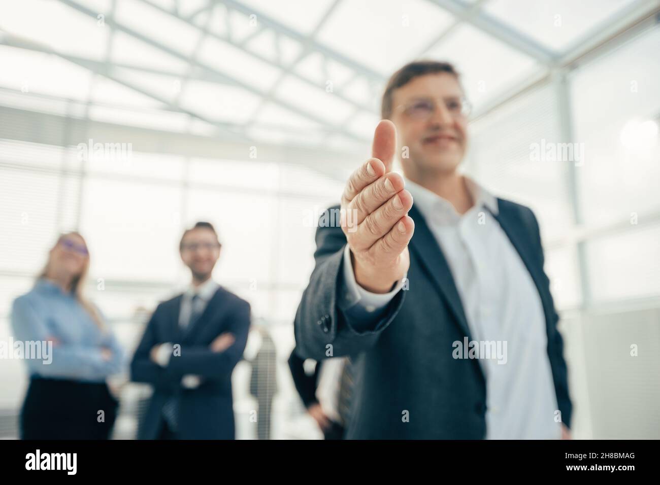 business man greeting you in the new office Stock Photo - Alamy