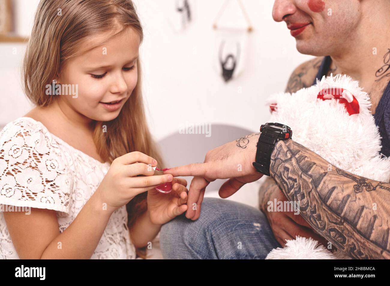 Funny time Tattoed father in a cap and his child are playing at home ...