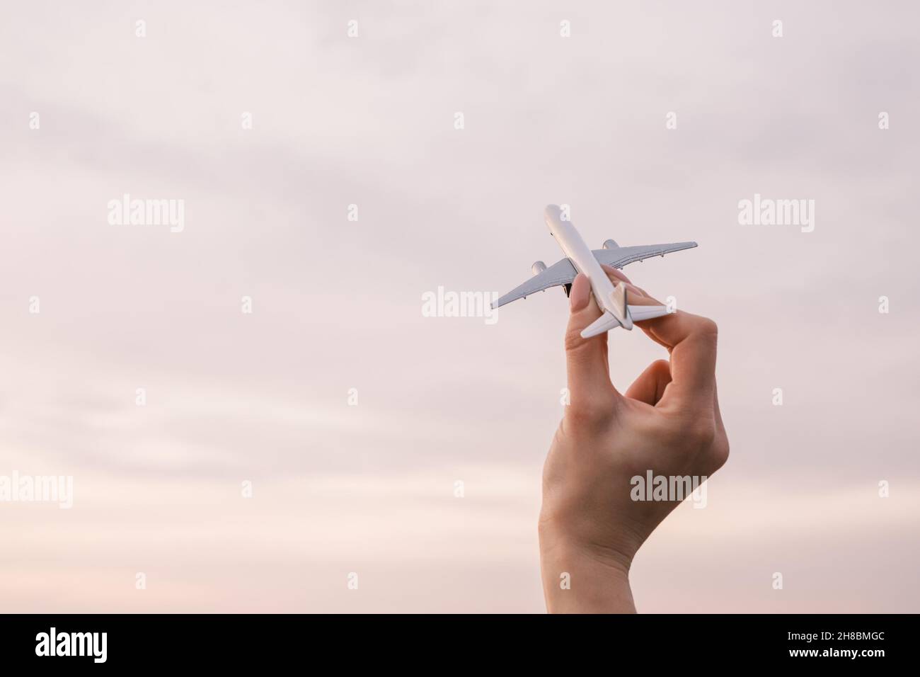Airplane model in a female hand in the background sky Stock Photo - Alamy