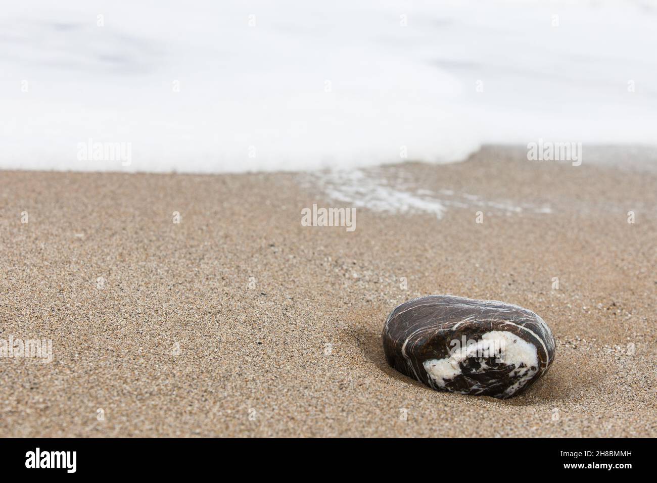 Single stone at the beach Stock Photo - Alamy