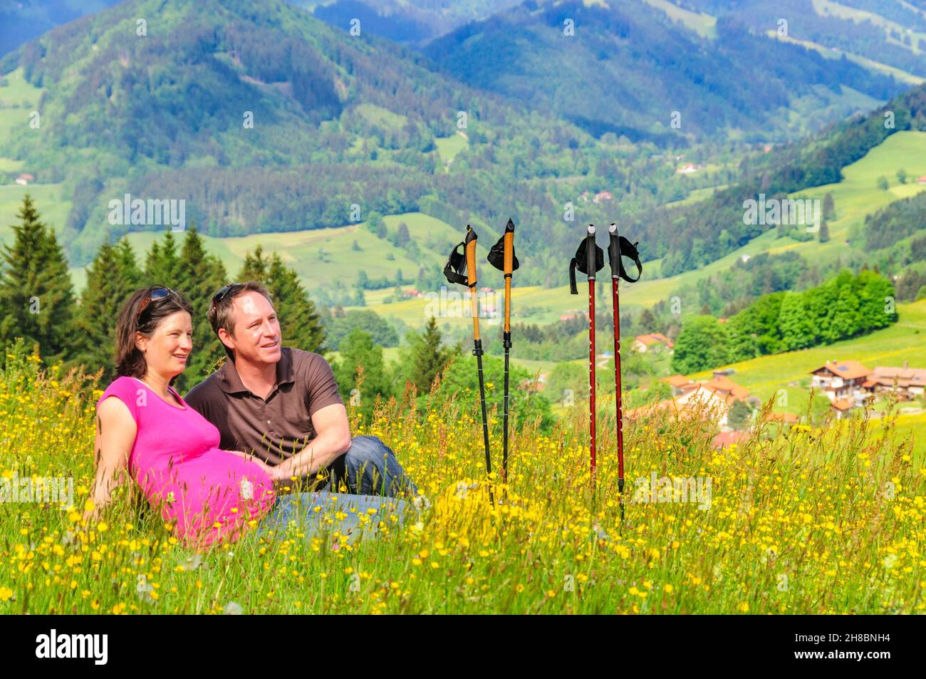 Expectant parents relax in a flower meadow Stock Photo - Alamy