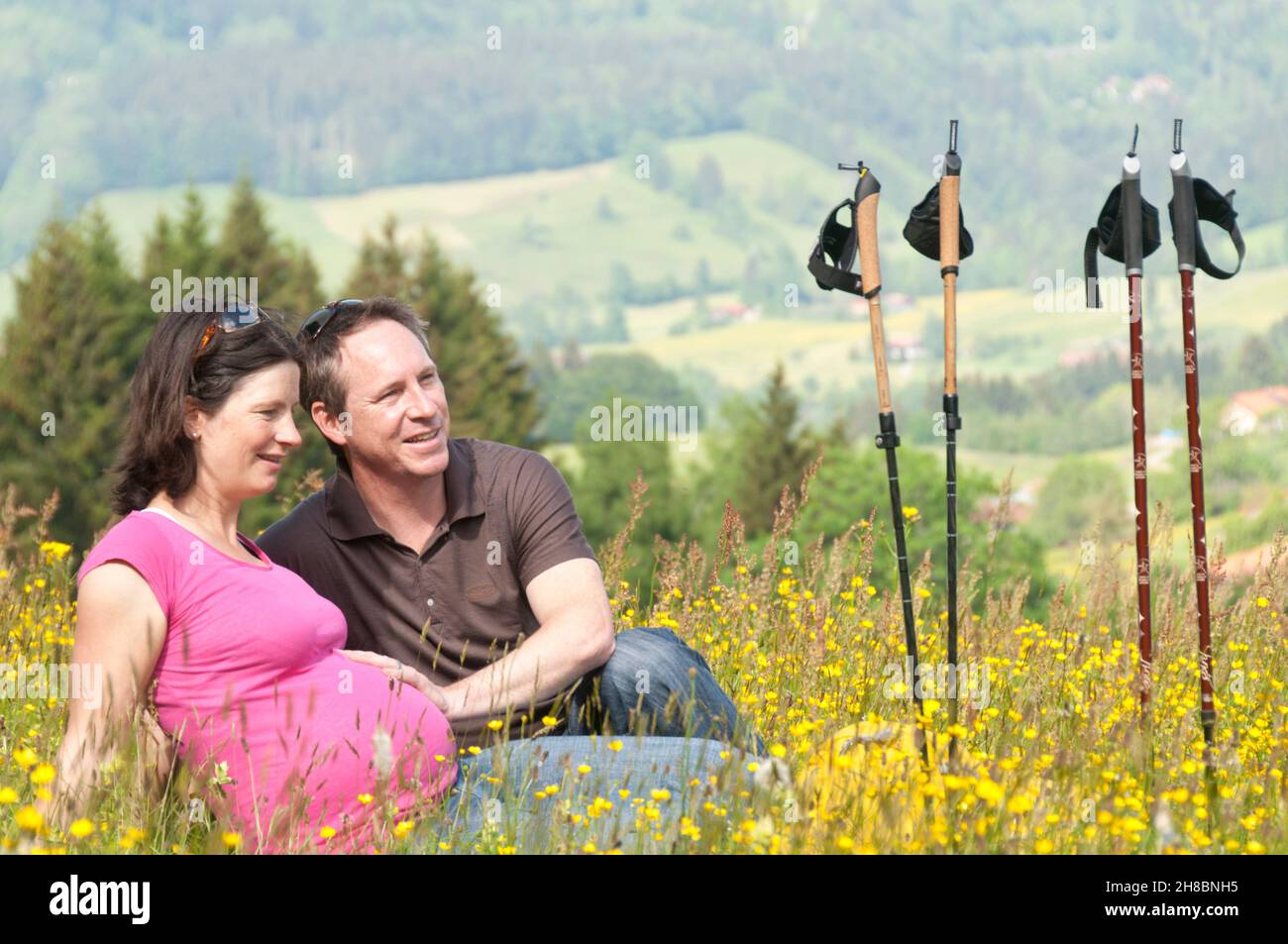 Expectant parents relax in a flower meadow Stock Photo - Alamy