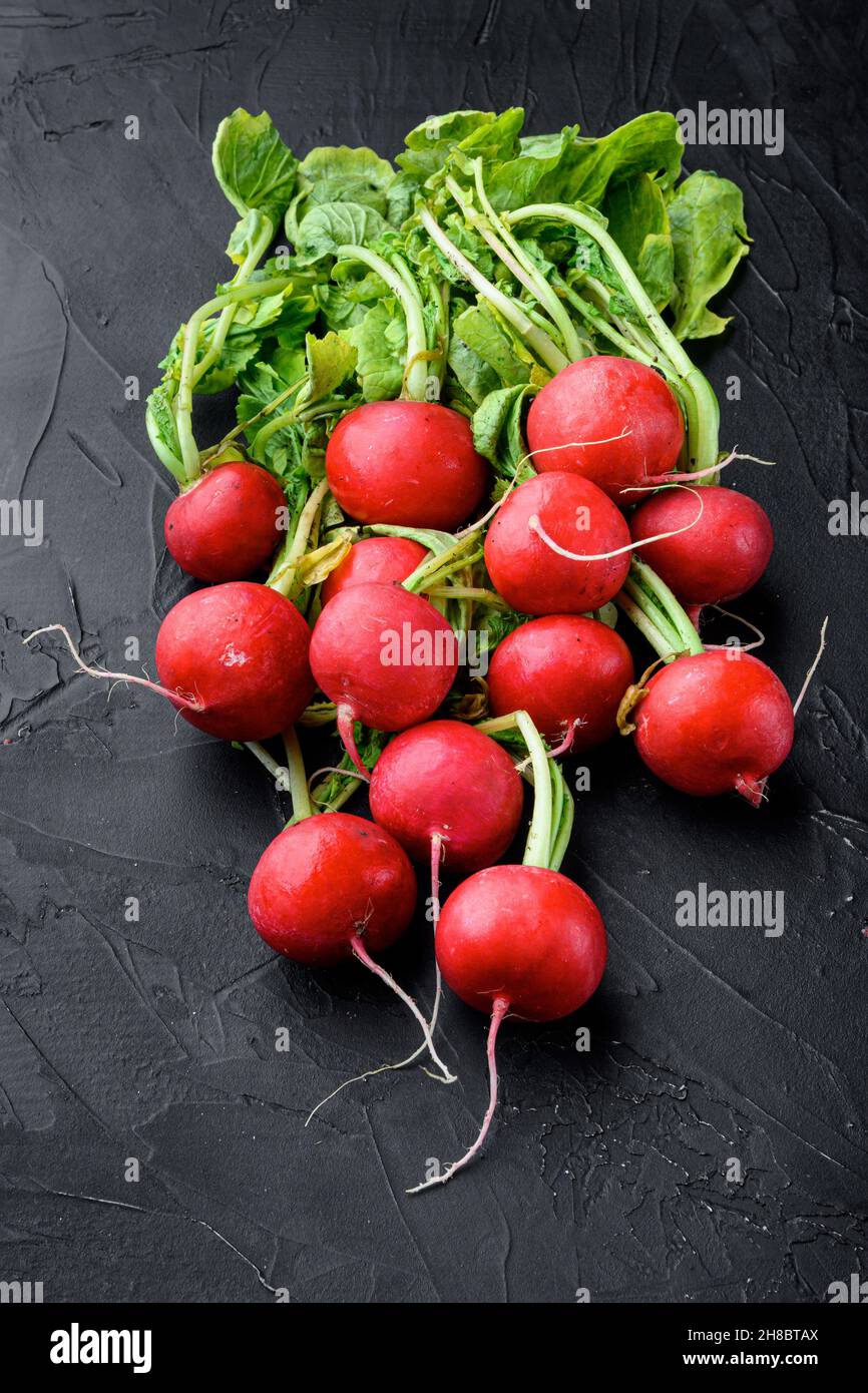 Red radish bunch with green leaves set, on black stone background Stock ...
