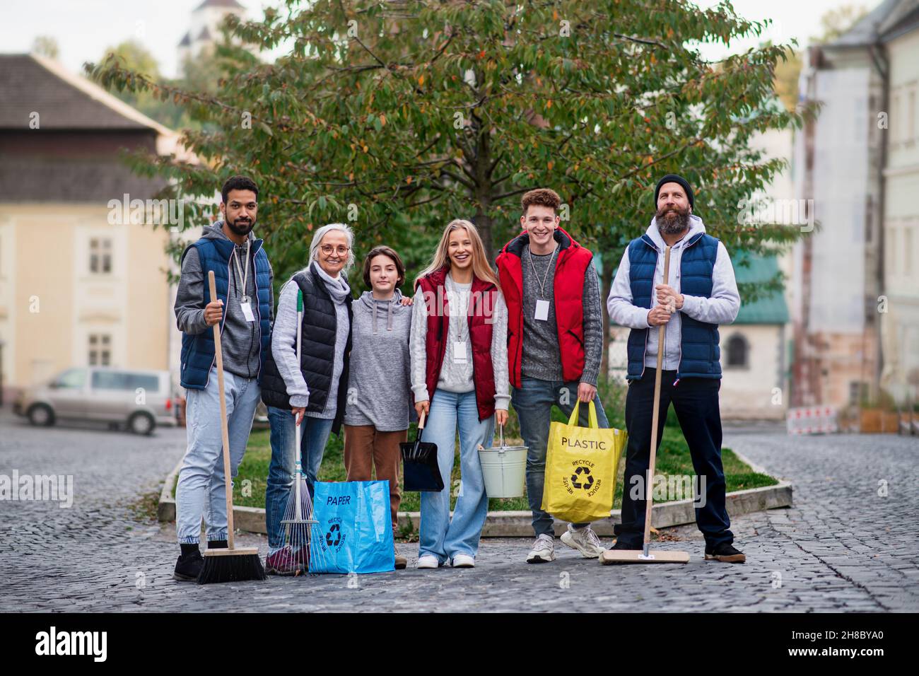 Group of happy volunteers looking at camera, ready to clean up street ...