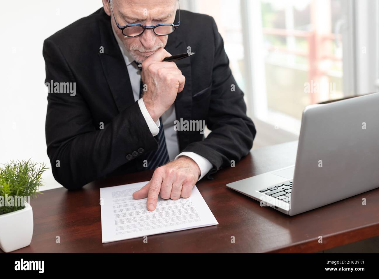 Senior businessman reading and checking document in office (Lorem ipsum ...