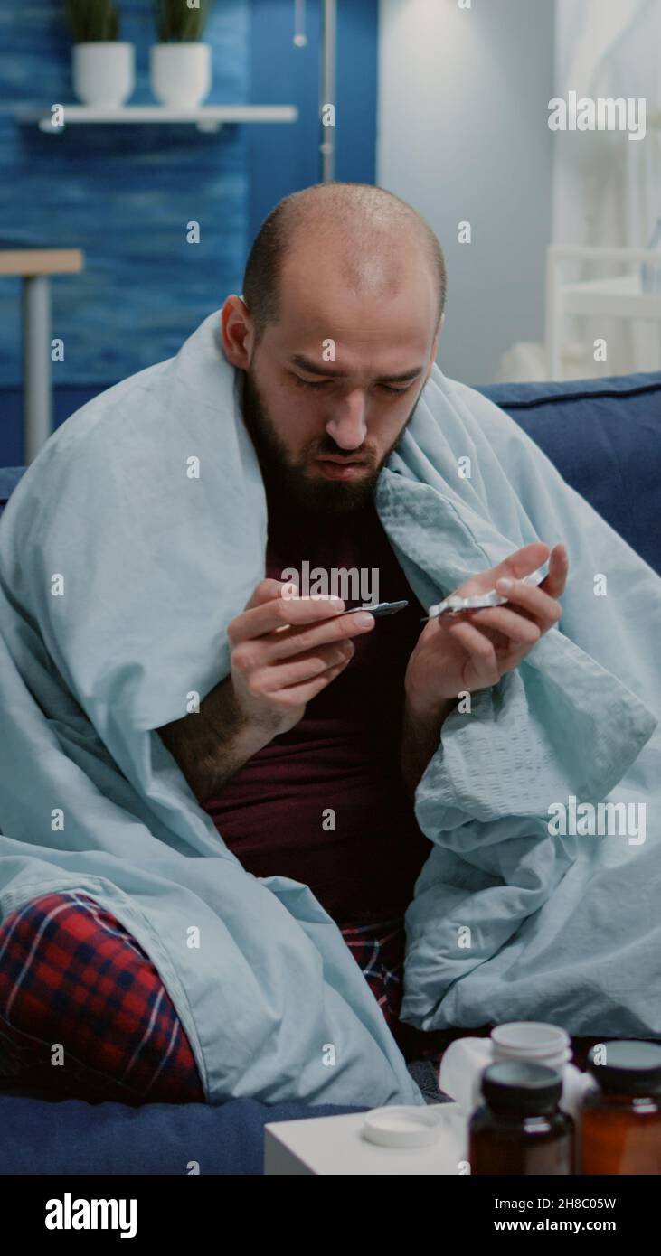 Person with sickness looking at tablets of capsules to cure disease and ...