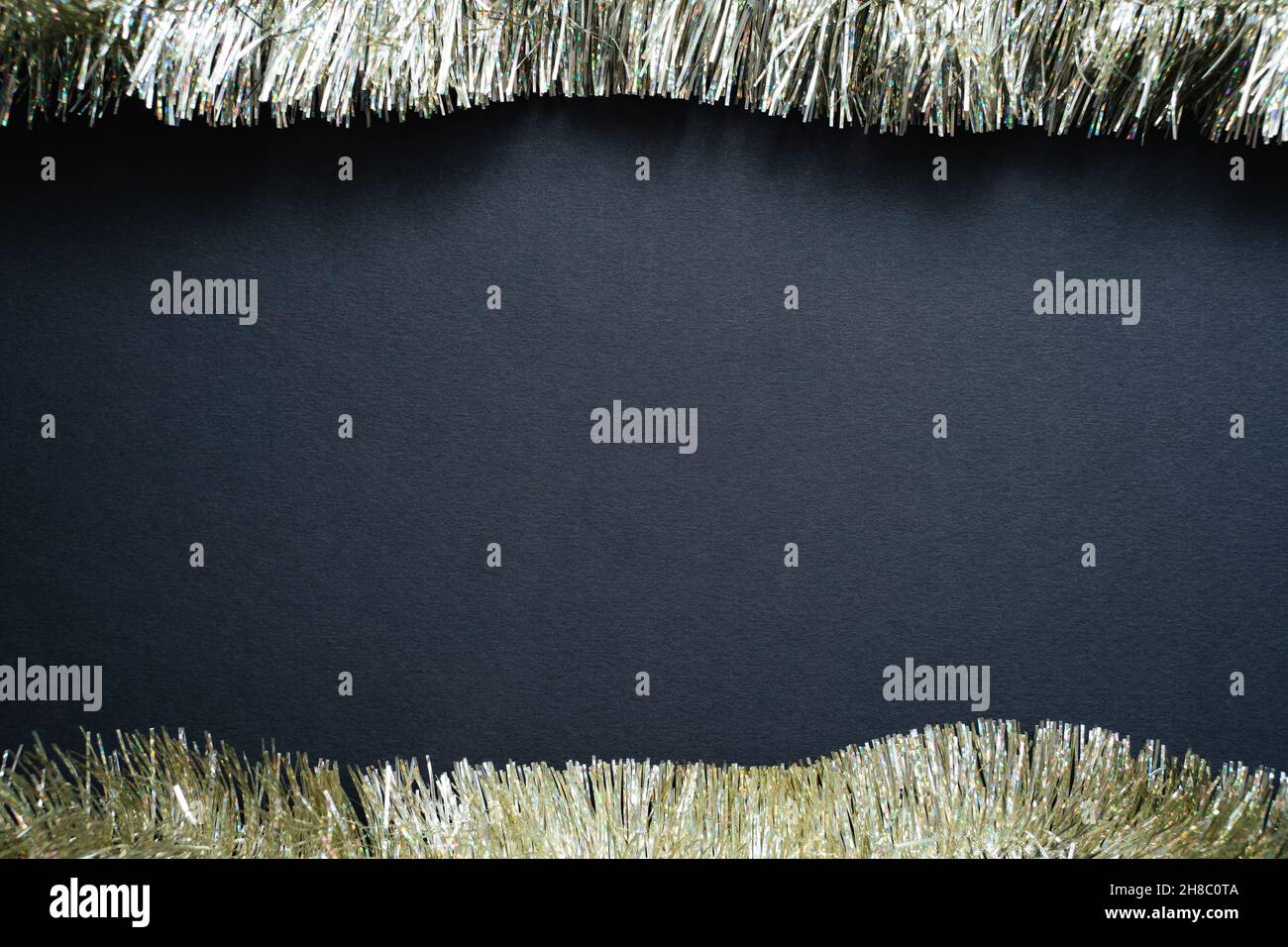 yellow holographic tinsel frame on black paper background. Christmas ...