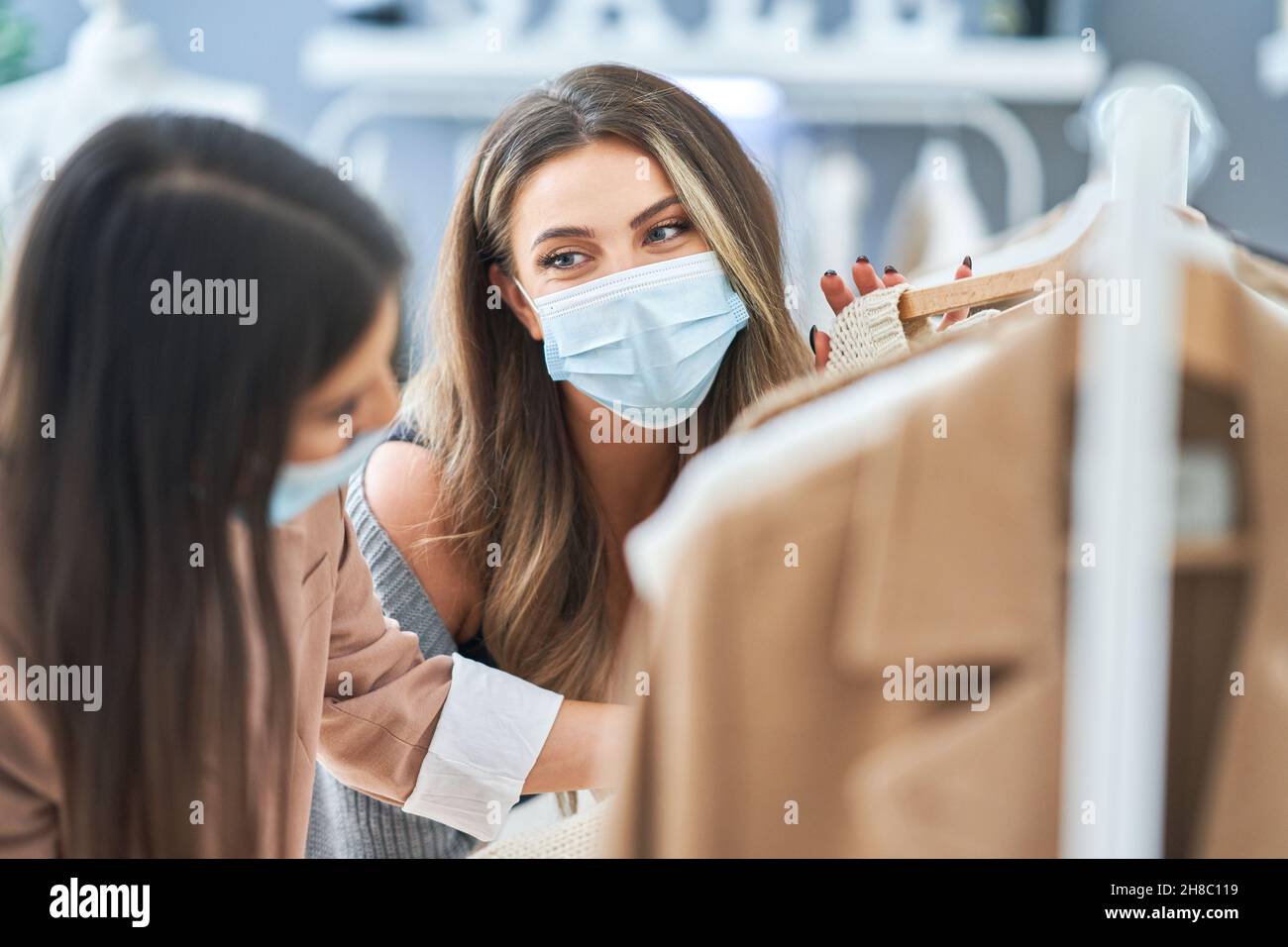 Girls on shopping in store with clothes wearing masks Stock Photo - Alamy