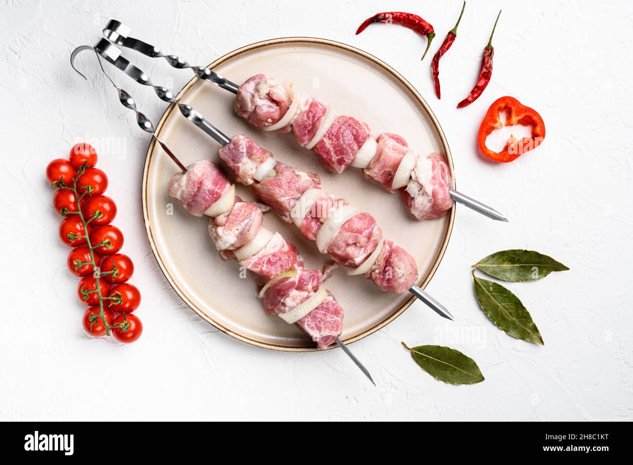 Marinated raw kebab on skewers set, top view flat lay, on white stone ...