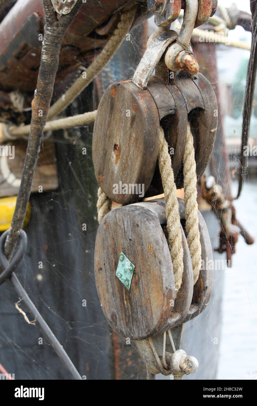 the wooden oval pulleys of a rope on a sailboat Stock Photo - Alamy