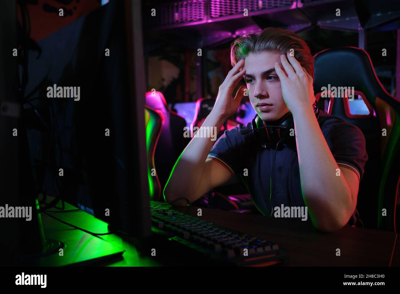 Professional young caucasian gamer playing online on his PC. He upset ...