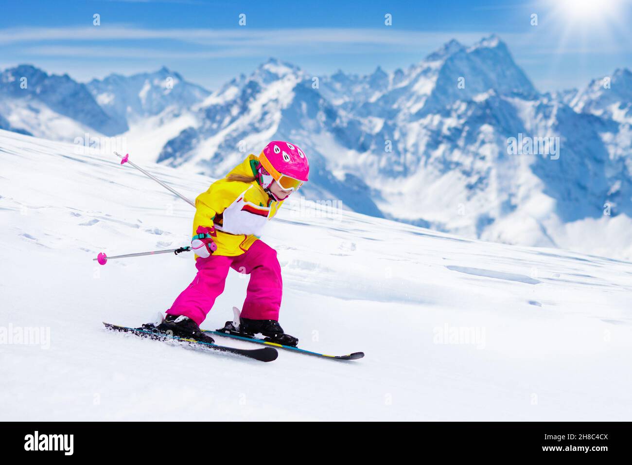 Child skiing in mountains. Active toddler kid with safety helmet ...
