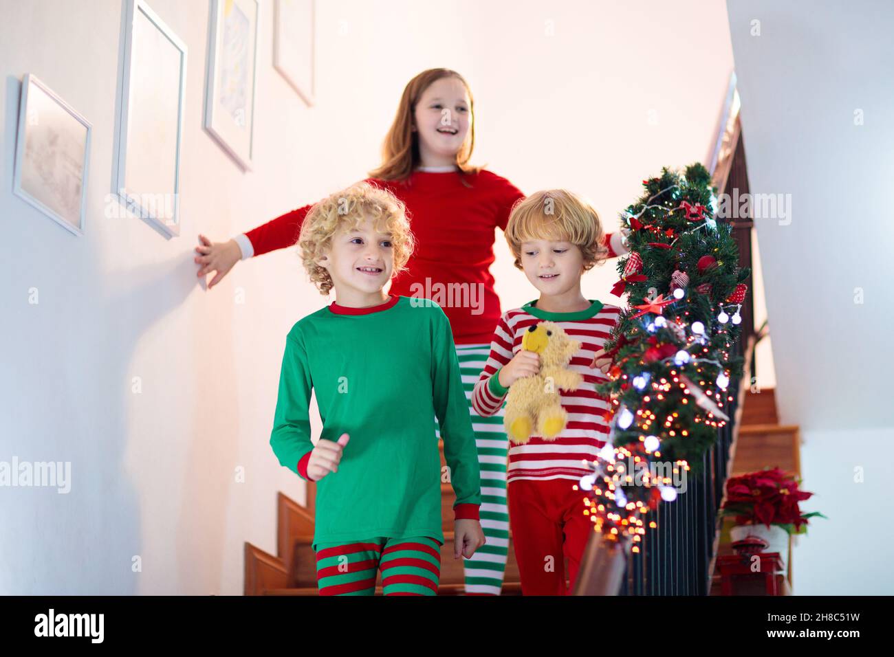 Kids running stairs on Christmas morning. Children in pajamas run ...