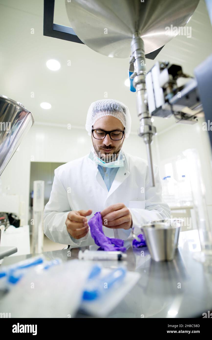 Laboratory technician putting on his gloves and preparing for work ...