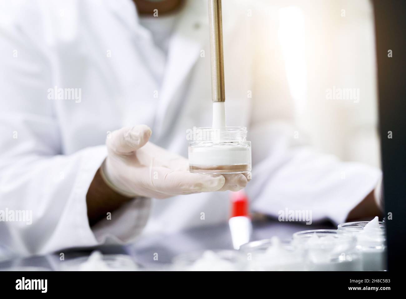 Hand moisturizing product. Laboratory worker holding glass, filling it ...