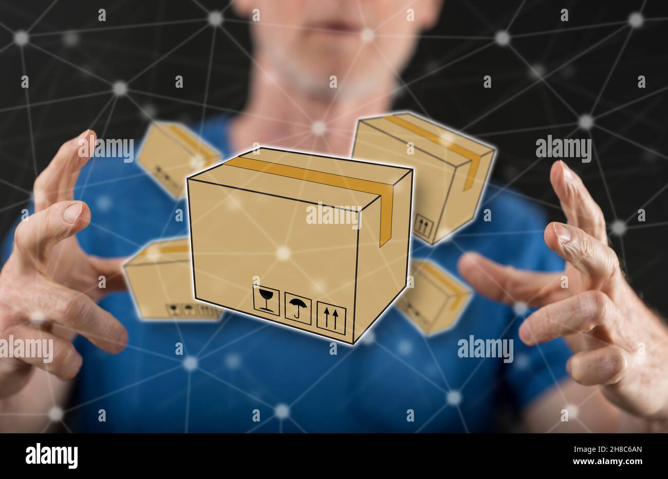 Packaging concept between hands of a man in background Stock Photo - Alamy