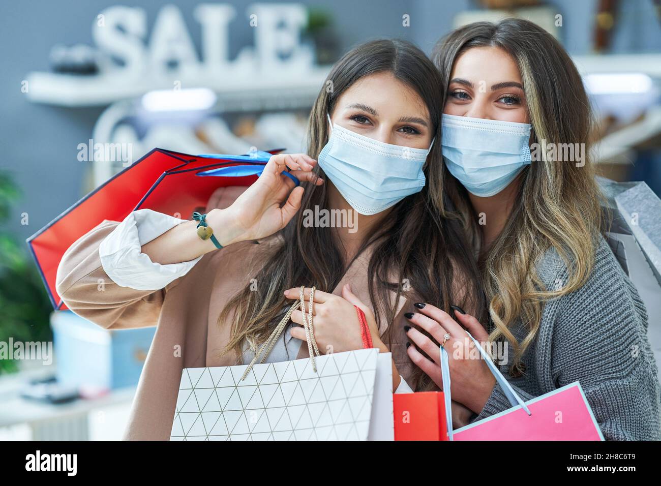 Girls on shopping in store with clothes wearing masks Stock Photo - Alamy