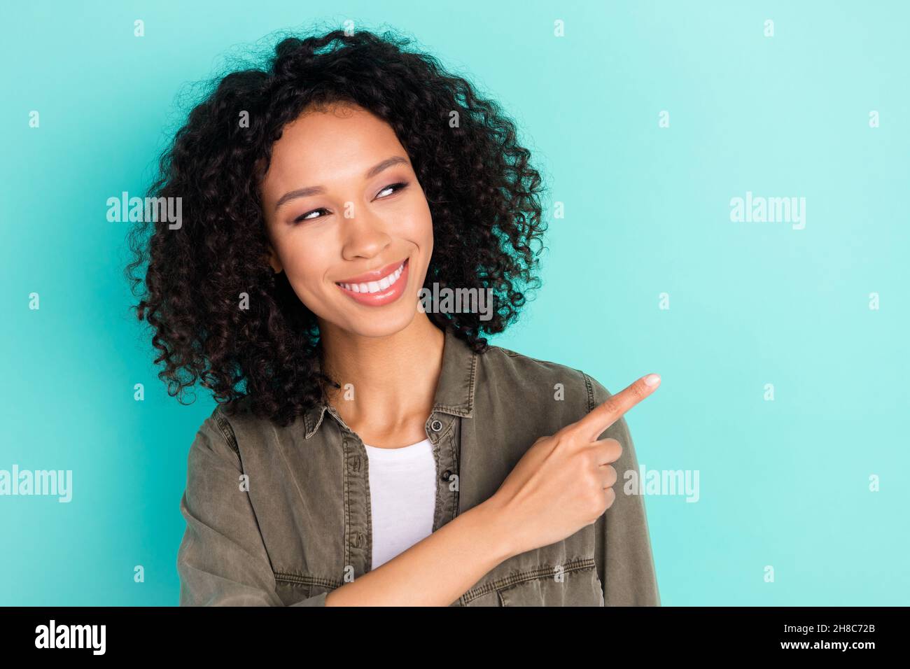 Portrait of attractive cheerful wavy-haired girl pointing indicate ...
