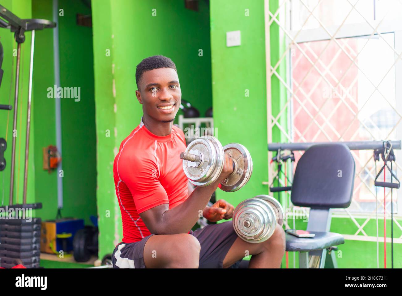 happy bodybuilder feeling excited as he is pumping dumbbell while ...