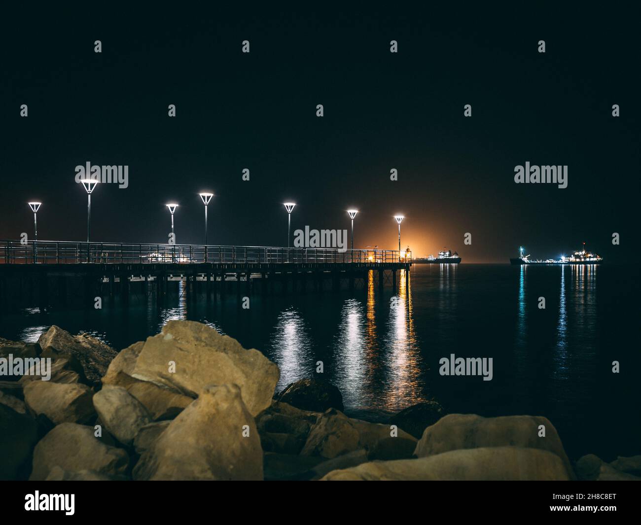 Night view of a sea with city lights and a bridge in Limassol, Cyprus ...