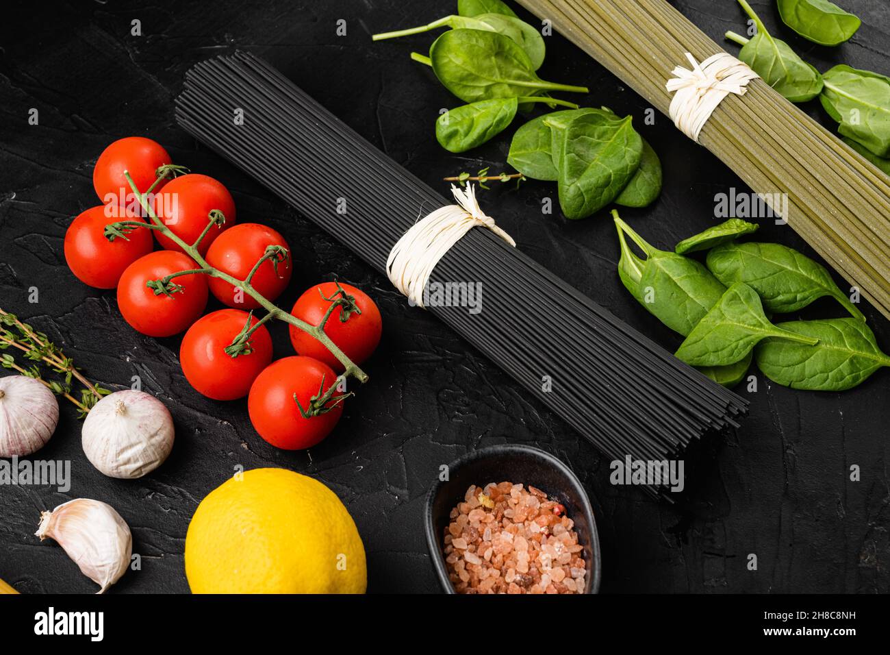 Dry colorful pasta spaghetti set, on black dark stone table background ...