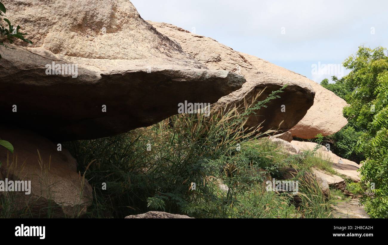 Three large rocks above the plants and a light blue sky Stock Photo - Alamy