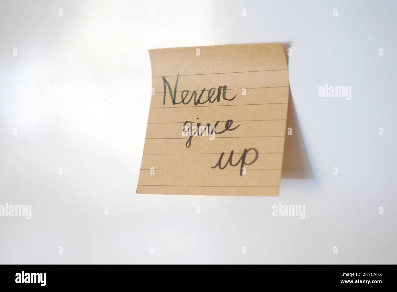 never give up word on stick note on table Stock Photo - Alamy