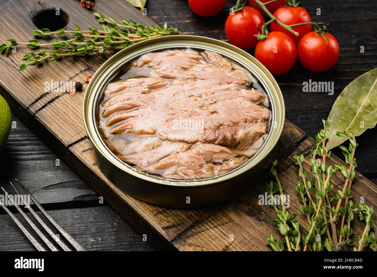 Open tuna tin set, on black wooden table background Stock Photo - Alamy