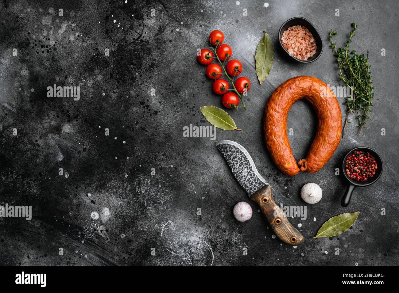 Cold smoked handmade sausage set, on black dark stone table background ...