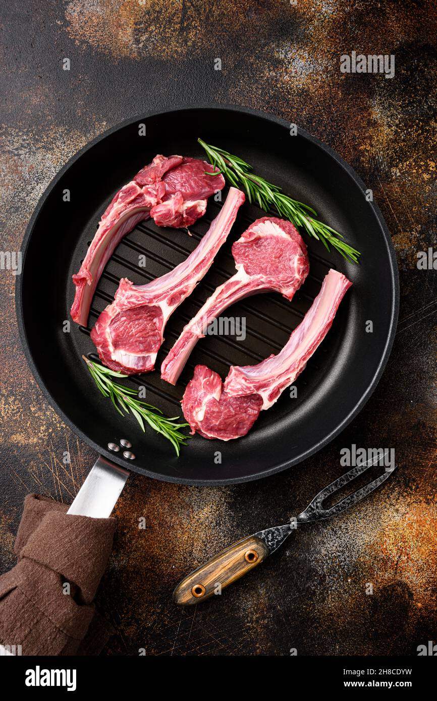 Fresh lamb rib chop set, on frying cast iron pan, on old dark rustic ...