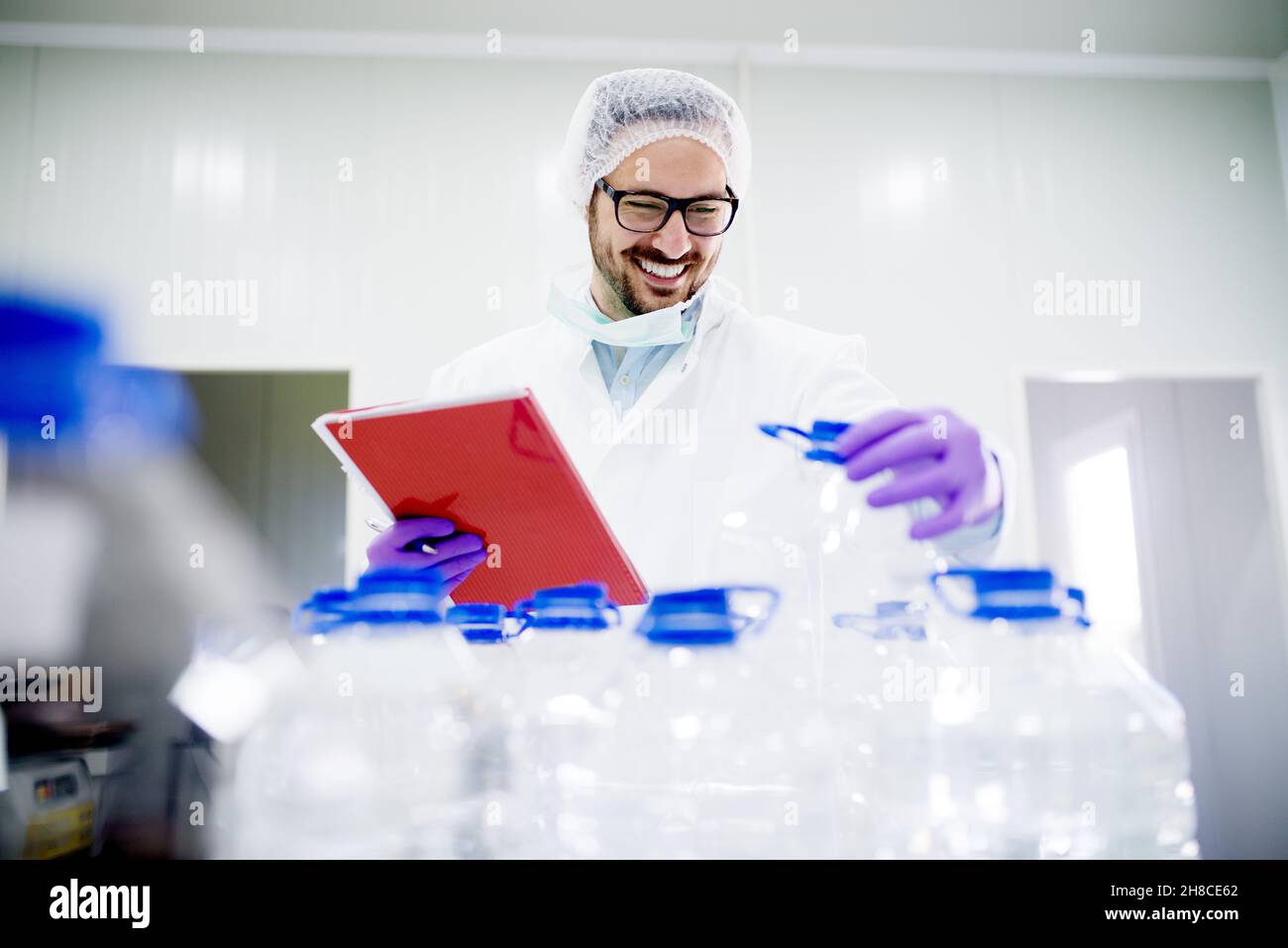 Chemist doing quality control of bottled water. Checking whether it ...