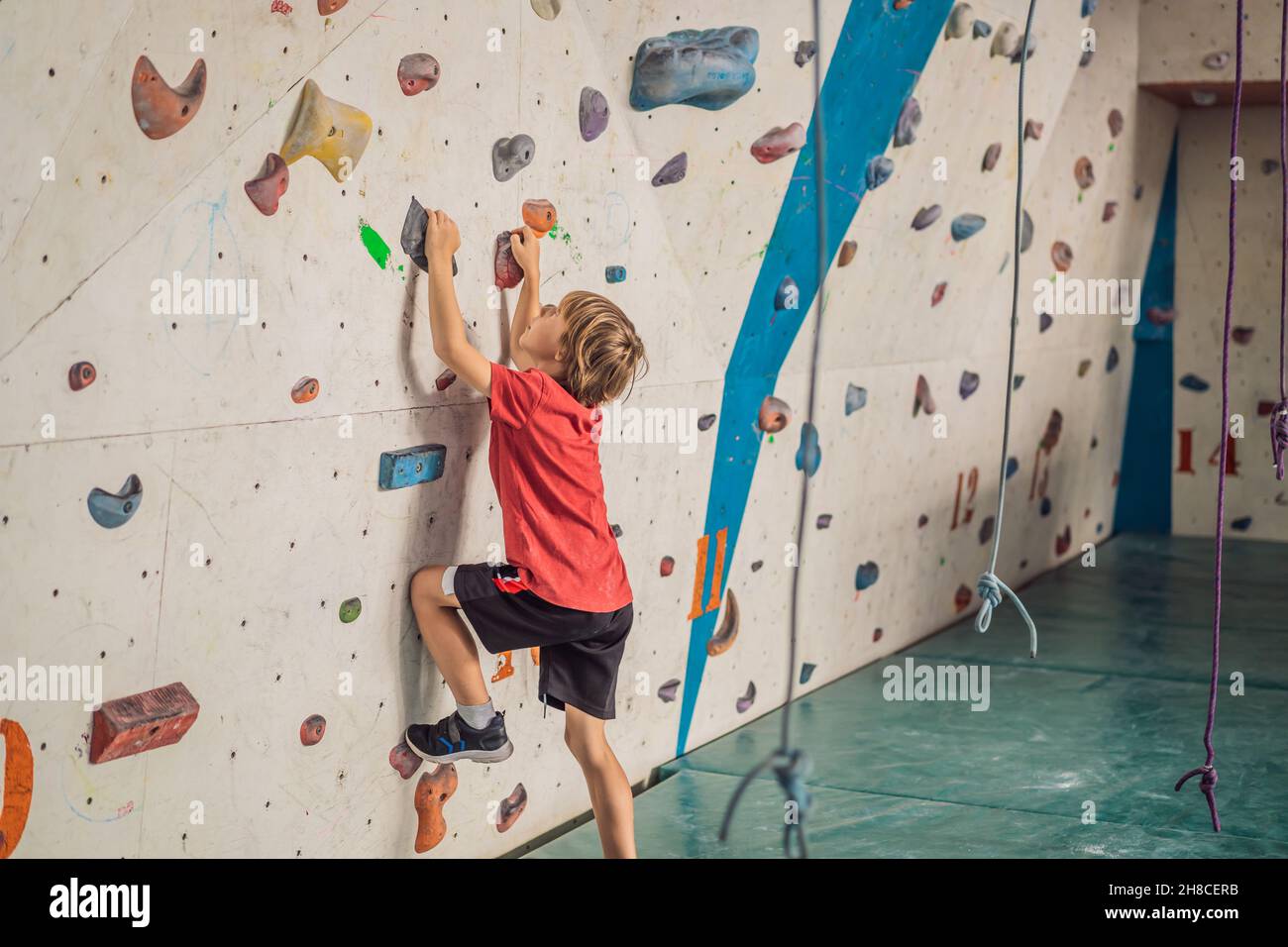 Boy at the climbing wall without a helmet, danger at the climbing wall ...