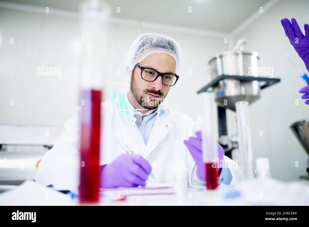 Laboratory technician doing blood analysis. Using measuring jugs and ...