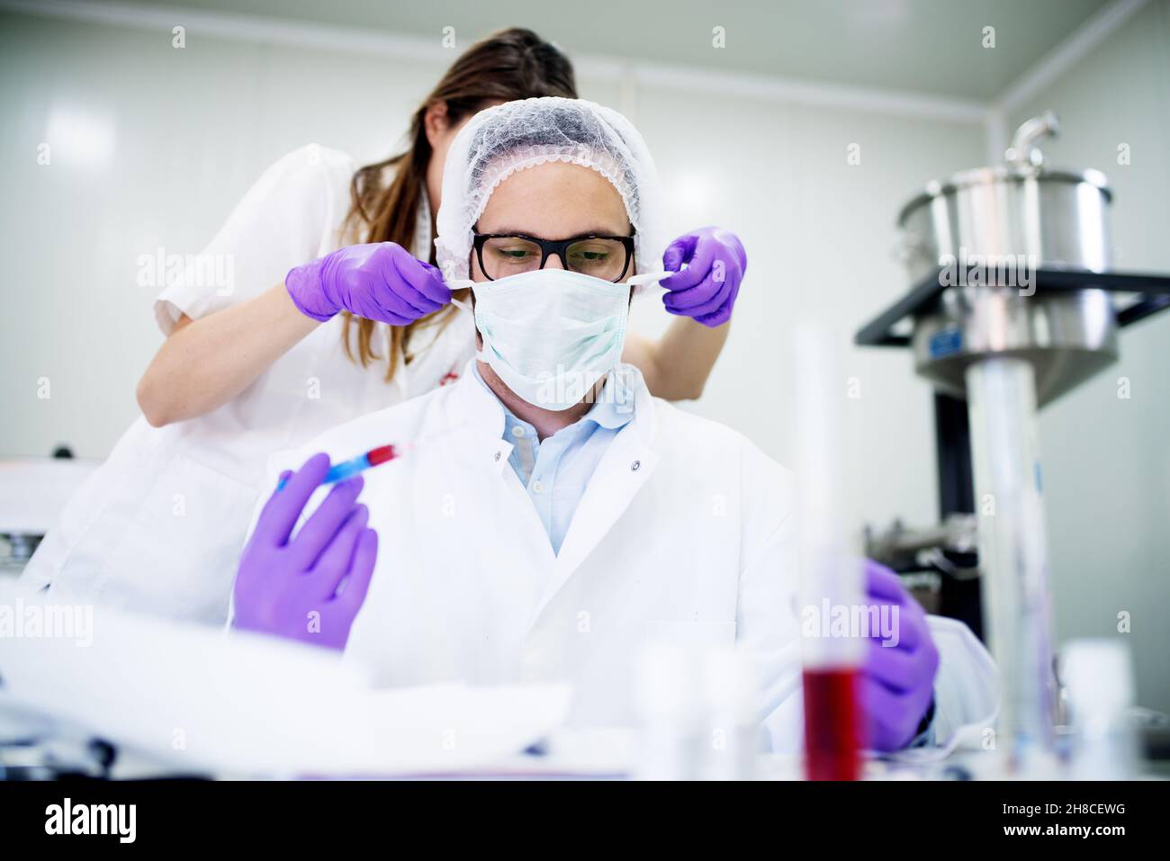 Laboratory technician doing blood analysis. Using measuring jugs and ...