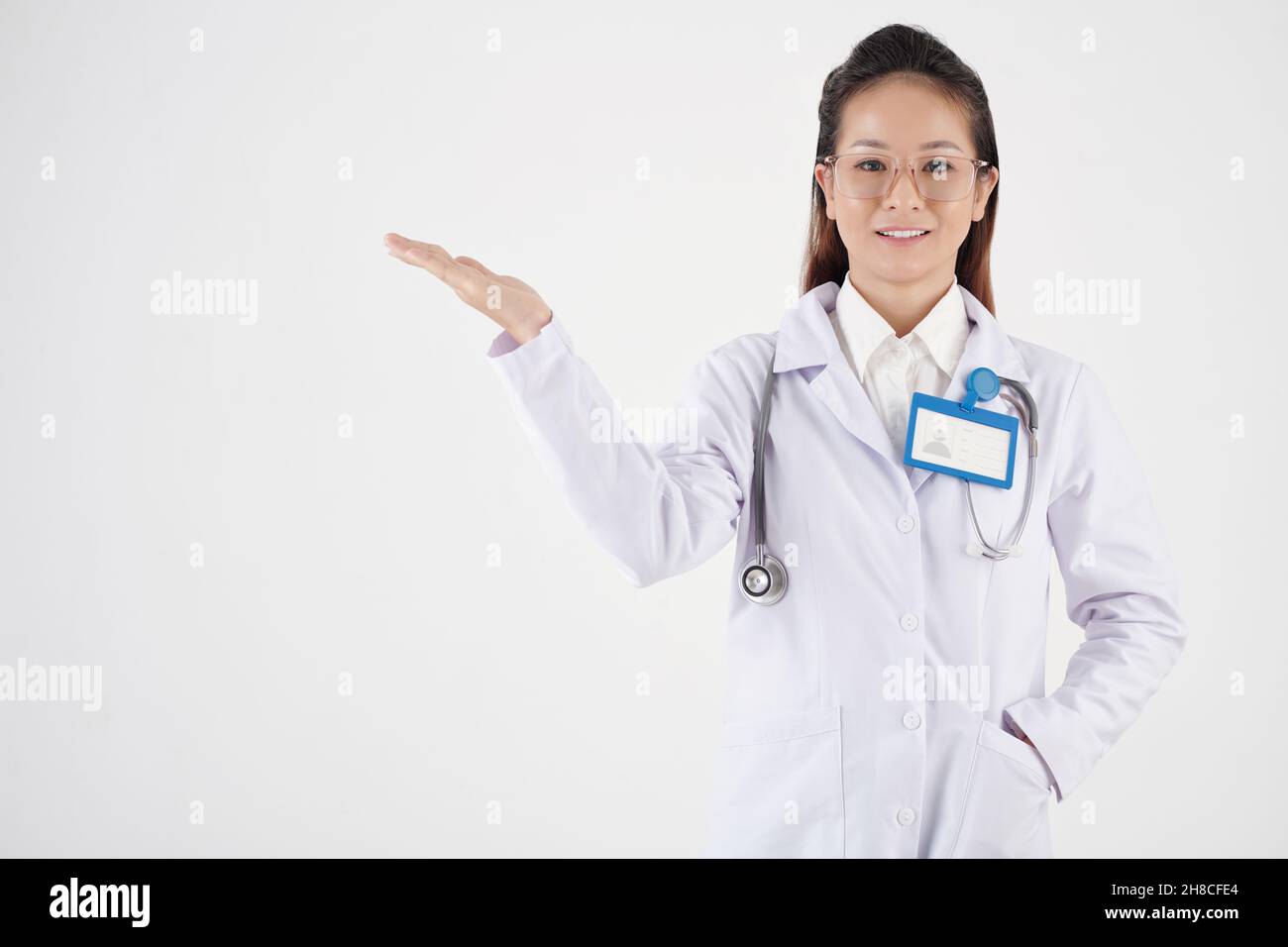 Smiling pretty young female physician with badge on chest showing ...