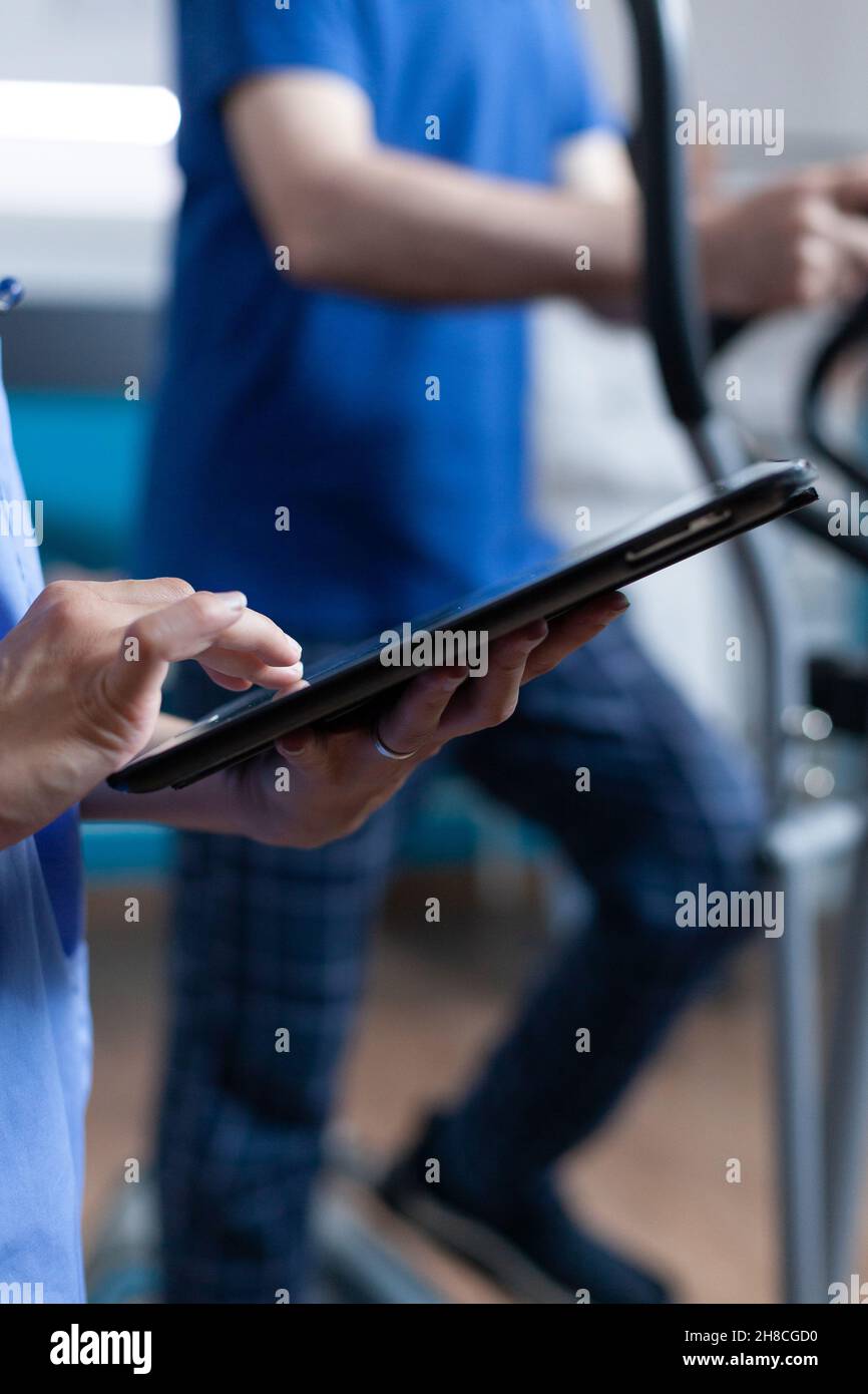 Close up of medical assistant touching tablet display to help aged ...