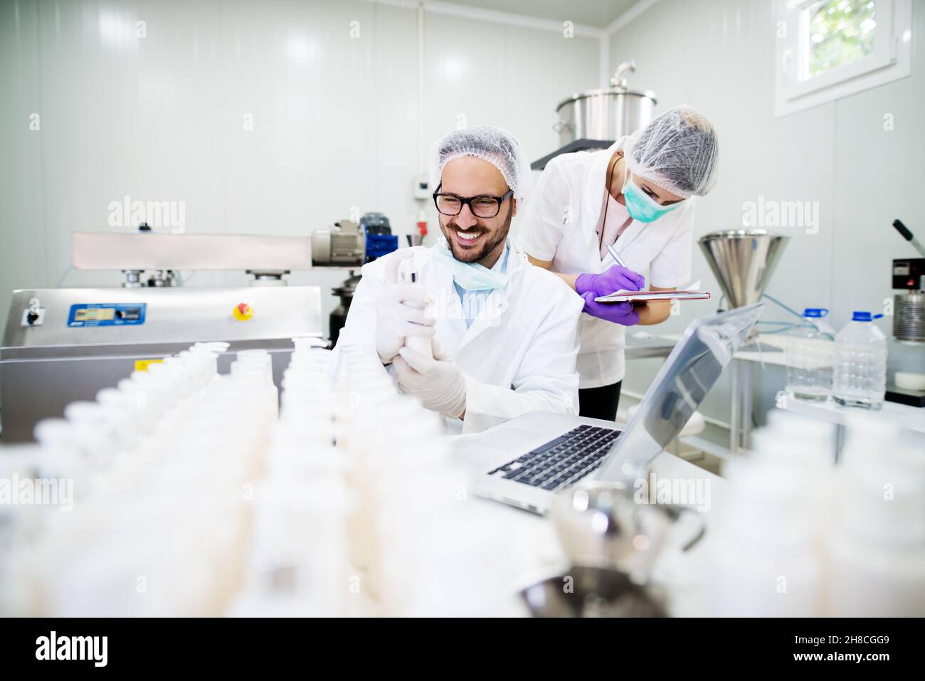 Young technologist making face care creams. Sitting in a cosmetic ...