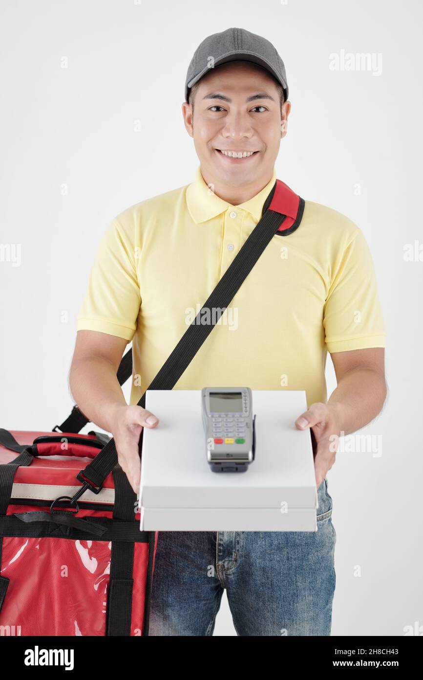 Cheerful delivery man giving boxes of pizza and payment terminal to ...