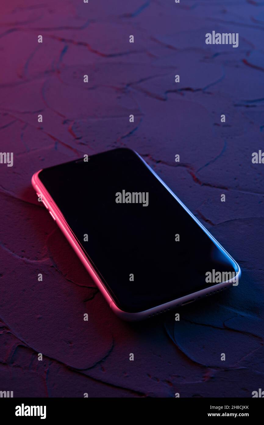 Mobile smartphone on dark red blue neon colors. Mock up.Perspective ...