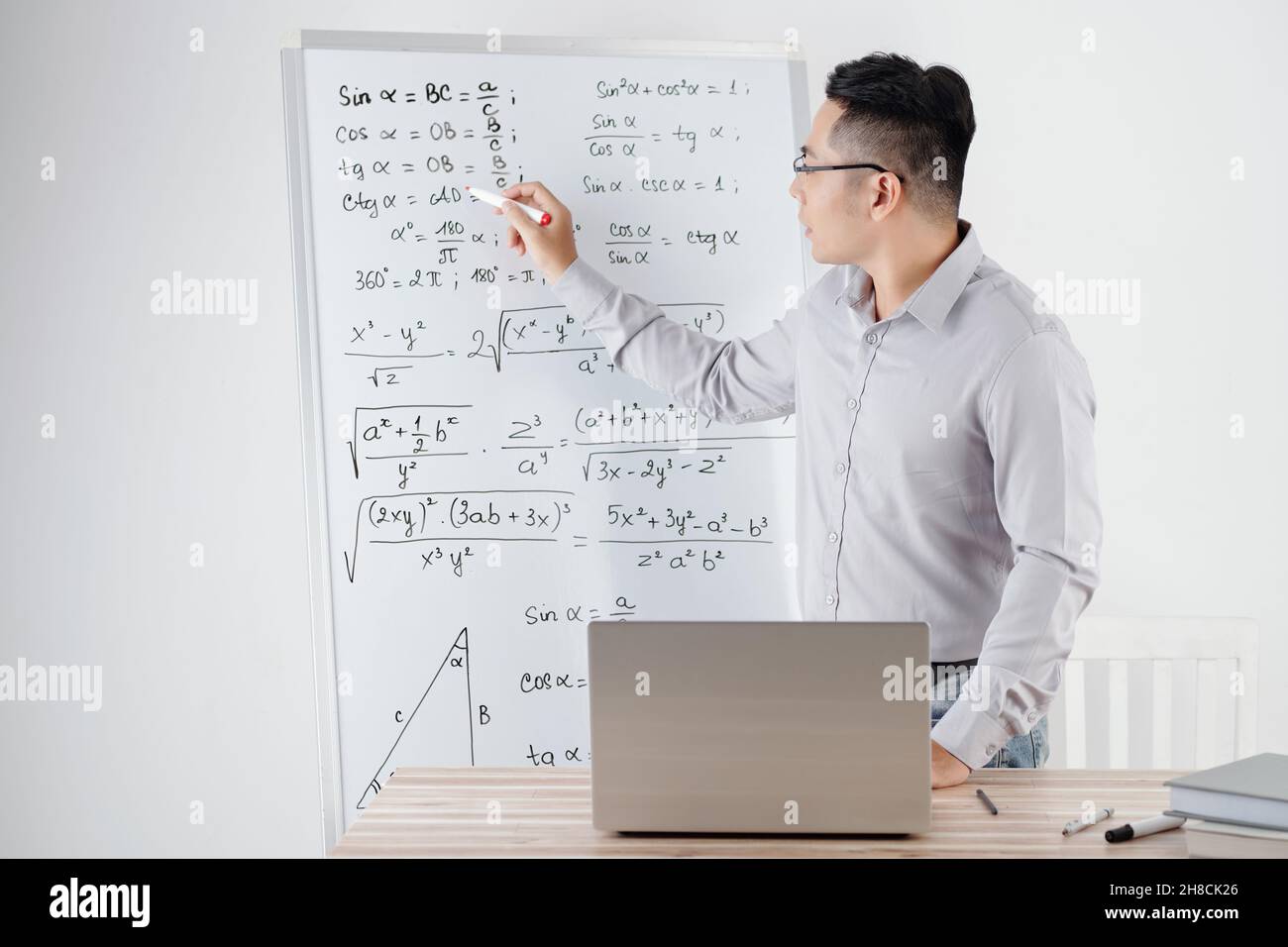 Math tutor conducting online lesson for students in front of opened ...