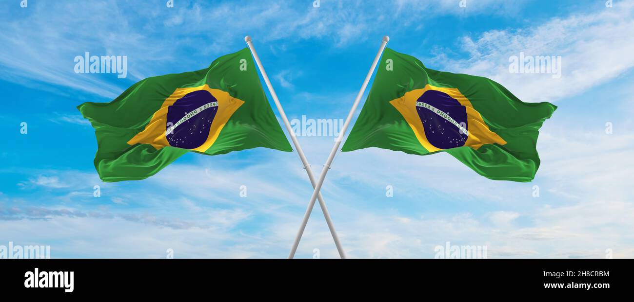 crossed national flags of Brazil and Brazil flag waving in the wind at ...