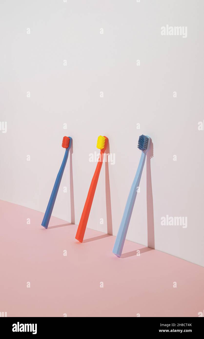 Trendy minimal composition with three colorful toothbrushes on pastel ...