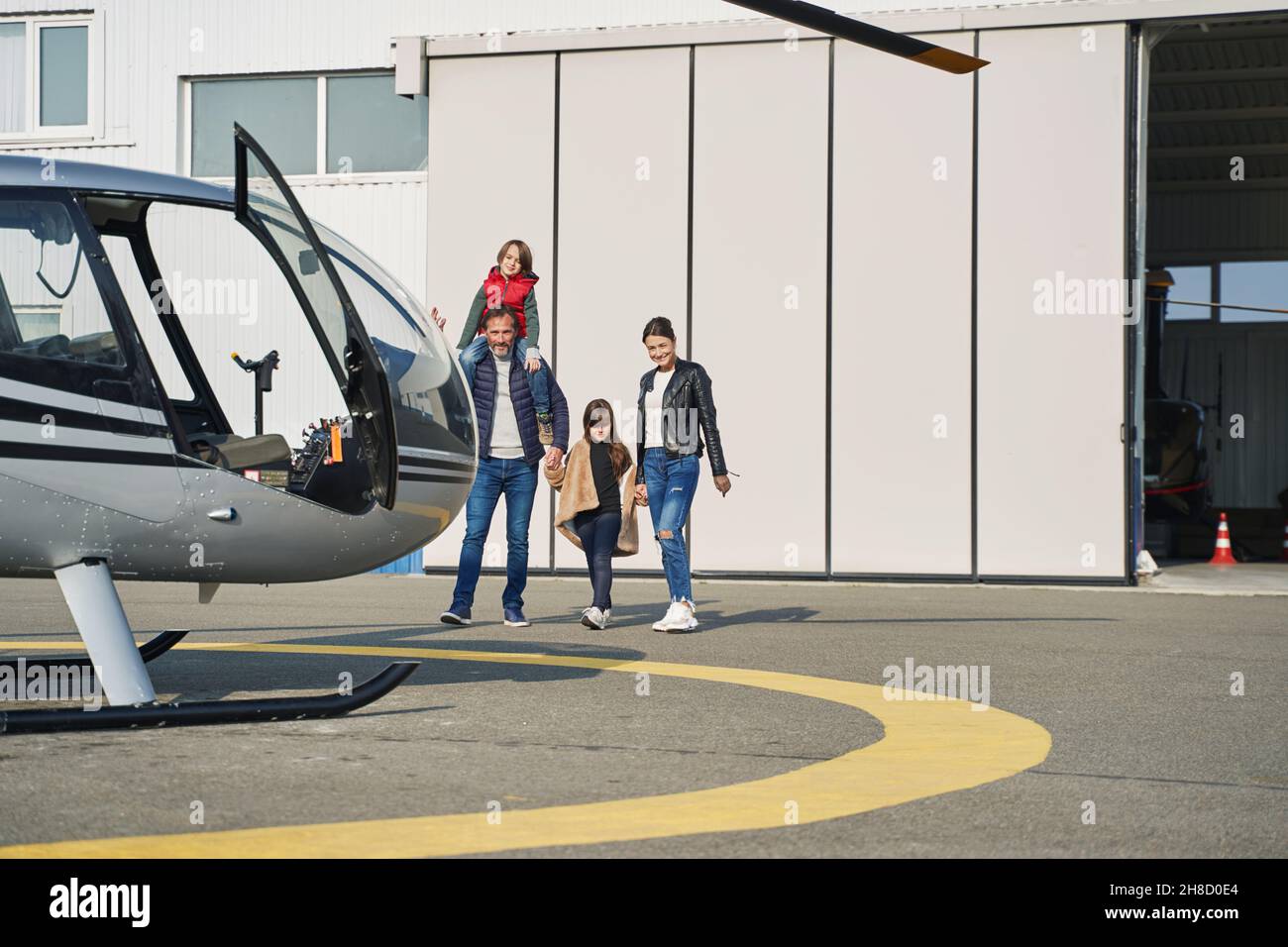 Parents and their kids going on a helicopter adventure Stock Photo - Alamy