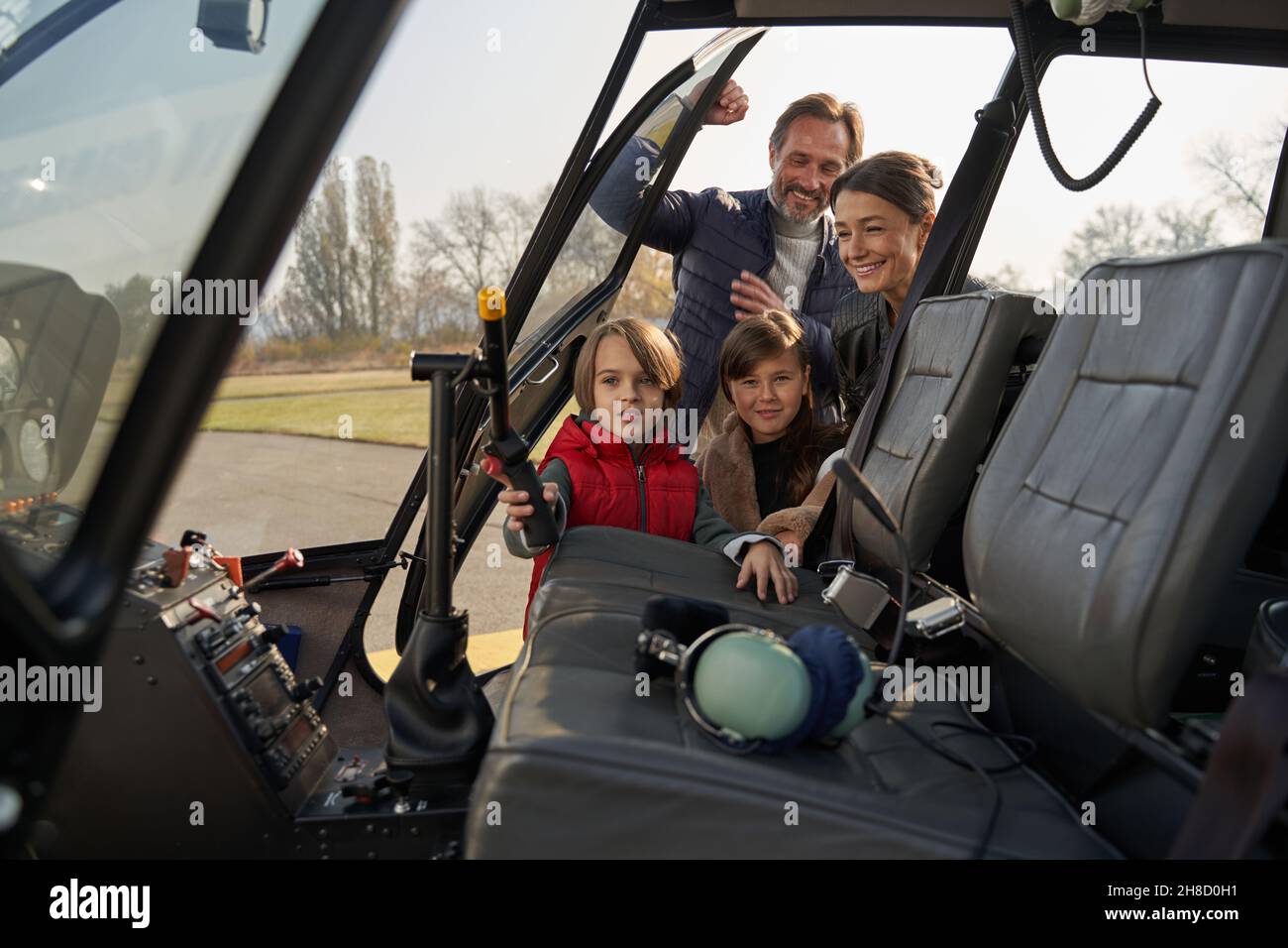 Cheerful family posing near an open cockpit of helicopter Stock Photo ...