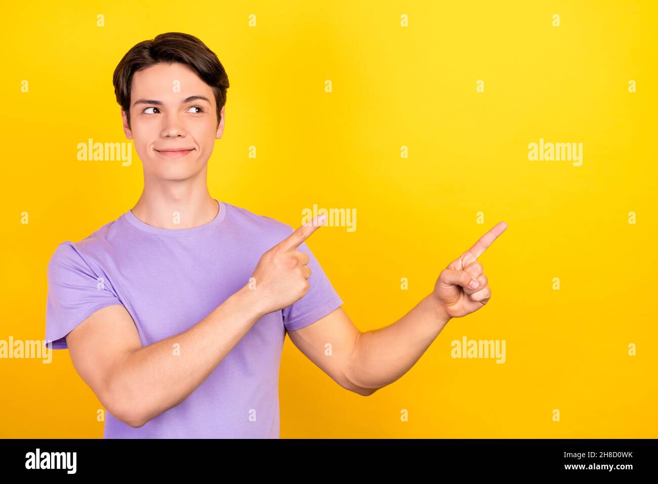 Portrait of attractive cheerful guy demonstrating copy space place ad ...