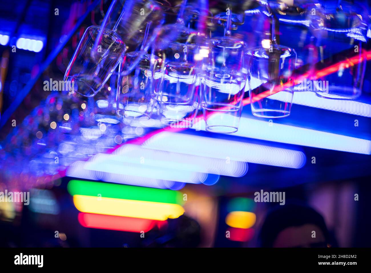 Glasses under bar counter. Nightlife. Neon lights Stock Photo - Alamy
