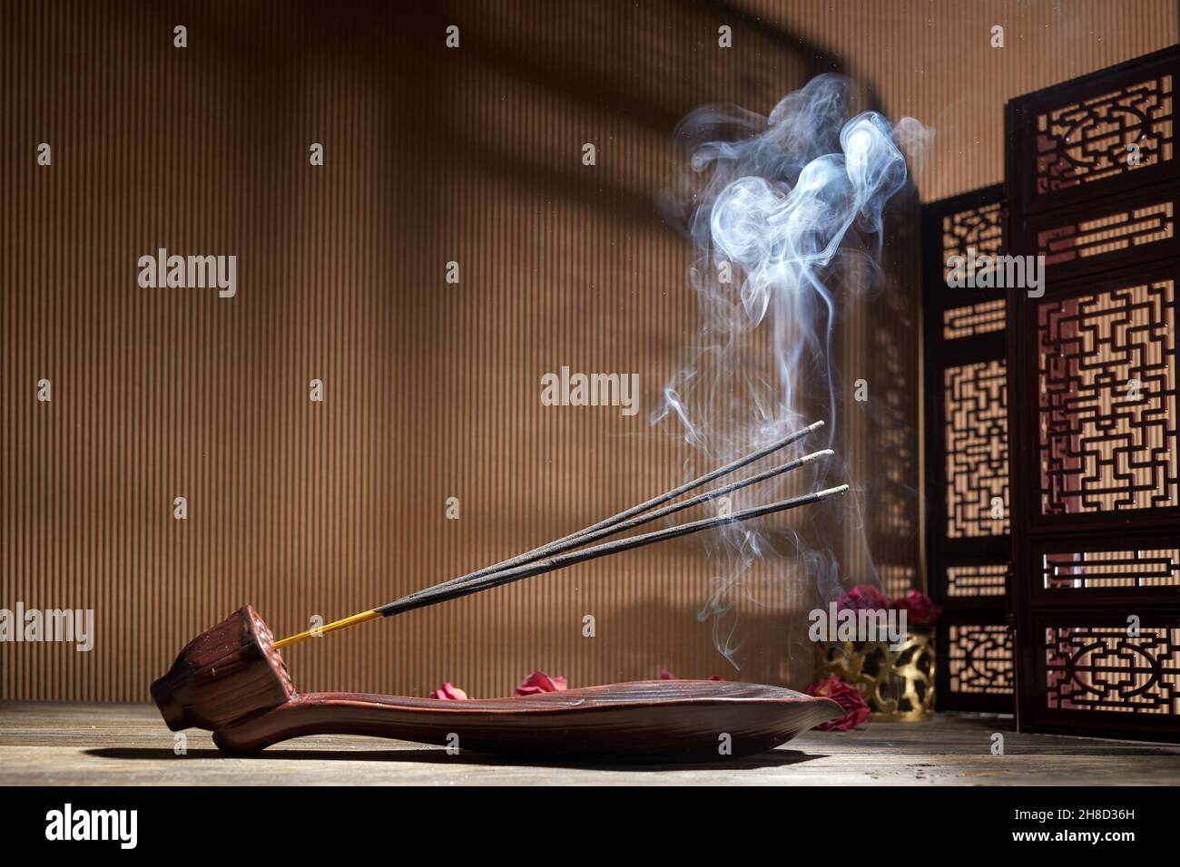 Smoke from burning incense sticks standing on lotus incense holder ...