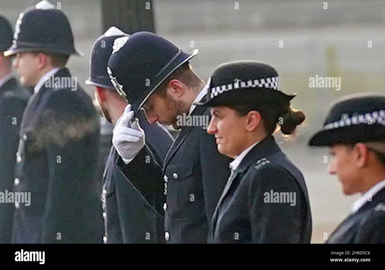 A police officer adjusts his helmet as he and his colleagues line Horse ...