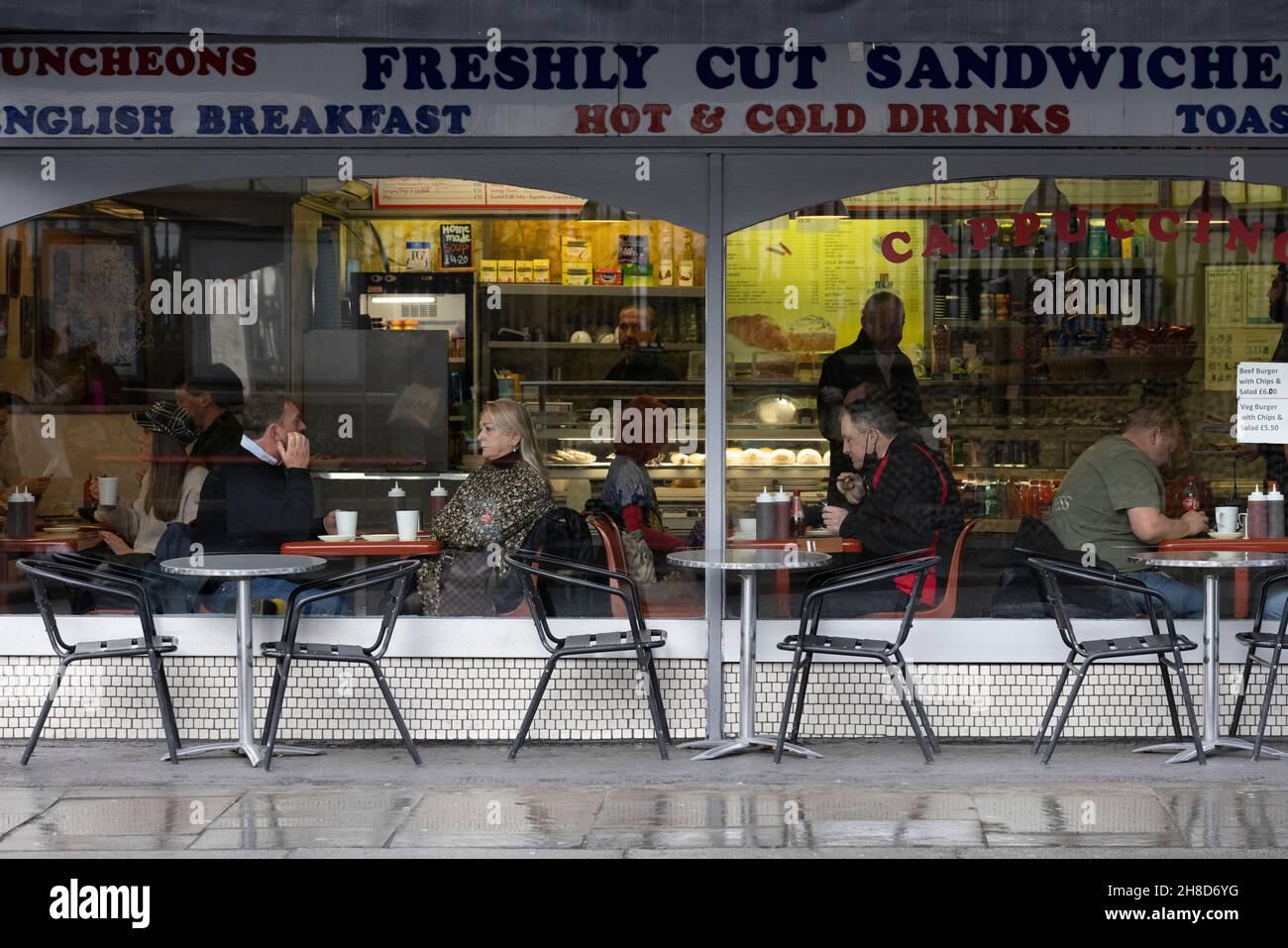 Diners sat enjoying their meals in a traditional English cafe in London ...